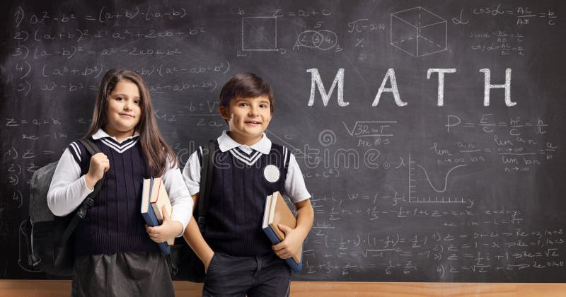 Schoolboy and Schoolgirl in Uniforms Standing in Front of a Chalkboard ...