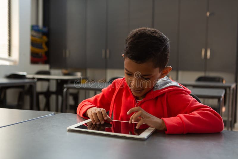 Schoolboy Using Digital Tablet at Desk in a Classroom Stock Photo ...