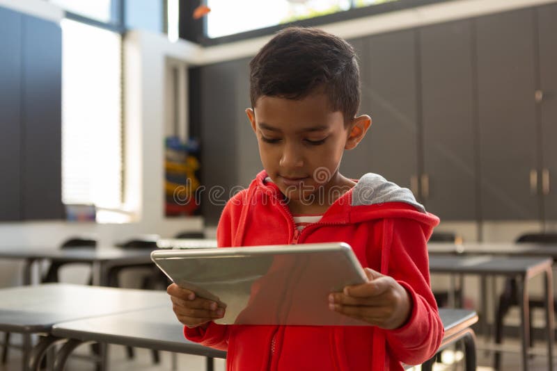 Schoolboy Using Digital Tablet at Desk in a Classroom Stock Image ...