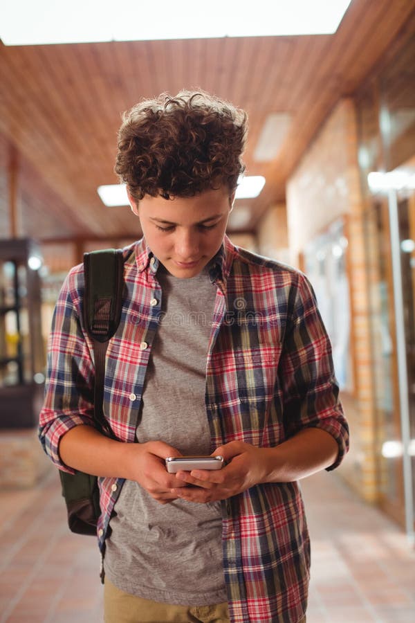 Schoolboy Using Mobile Phone in Corridor at School Stock Image - Image ...