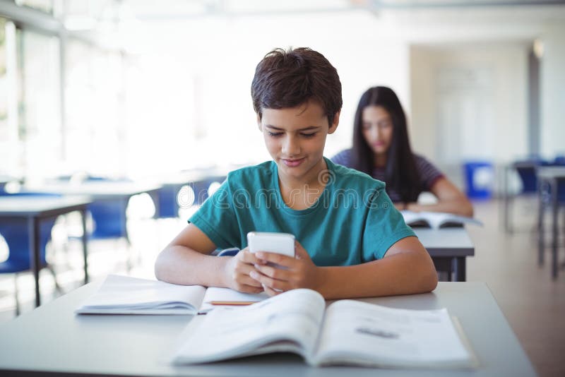 Schoolboy Using Mobile Phone while Studying in Classroom Stock Image ...