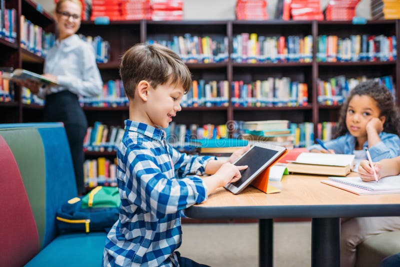 Schoolboy Using Tablet at Library Stock Photo - Image of intelligent ...