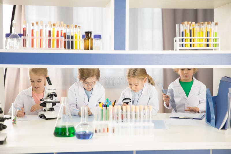 Schoolchildren in Lab Coats Studying Together Stock Photo - Image of ...
