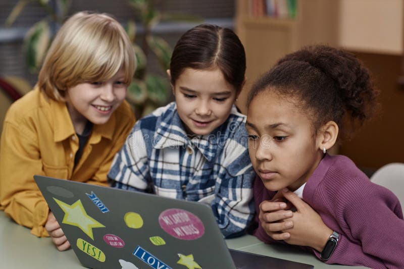 Schoolchildren Looking at Laptop Screen in Class Stock Photo - Image of ...