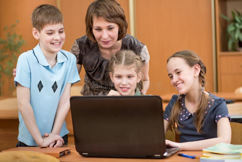 Teacher Using Computer with Students in Classroom Stock Photo - Image ...