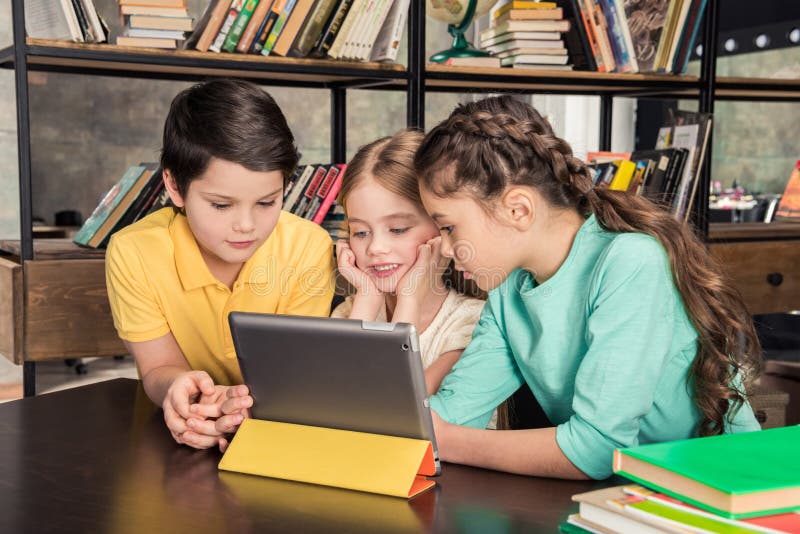 Schoolchildren Using Digital Tablet in Library Stock Image - Image of ...