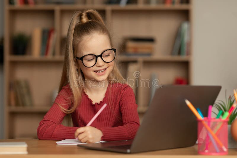 Schoolgirl Learning Online Using Laptop and Taking Notes at Home Stock ...