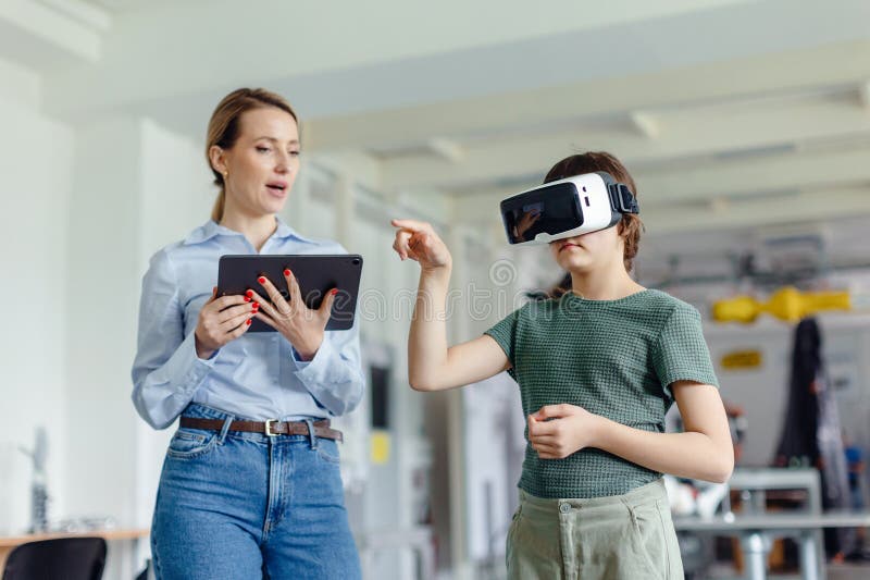 Schoolgirl Learning with VR Headset on Head. Teacher Using Modern ...