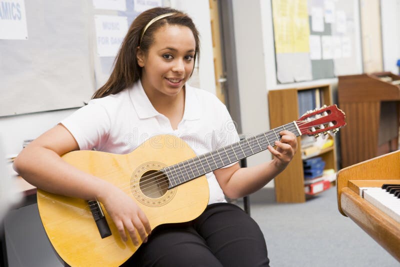 Schoolgirl Playing Guitar in Music Class Stock Photo - Image of ...