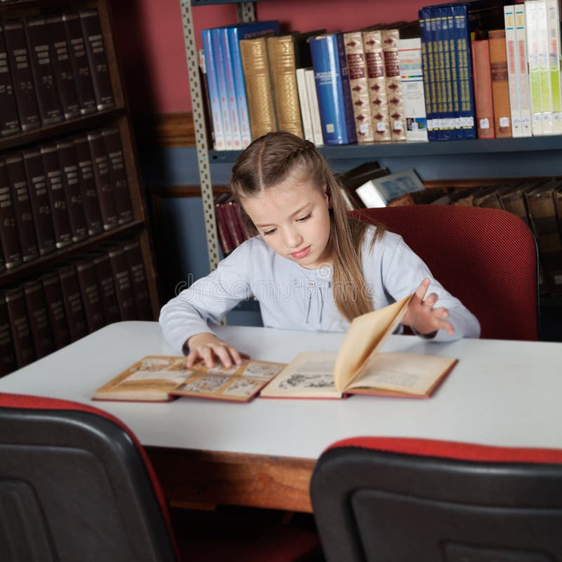 Schoolgirl Reading Books at Table Stock Photo - Image of bookshelf ...