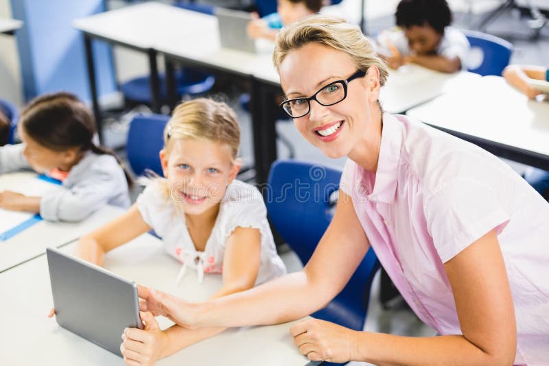 Schoolgirl and Teacher Using Digital Tablet in Classroom Stock Photo ...