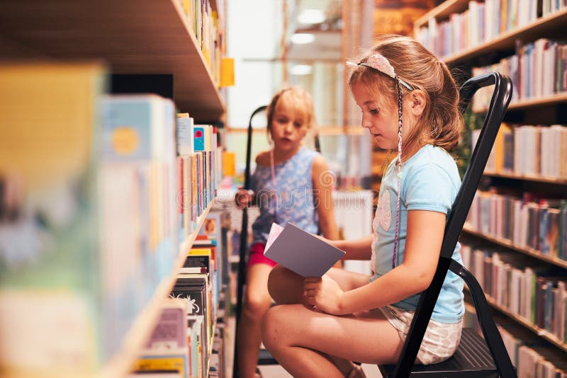 Two Schoolgirls Choosing Books in School Library. Primary School ...