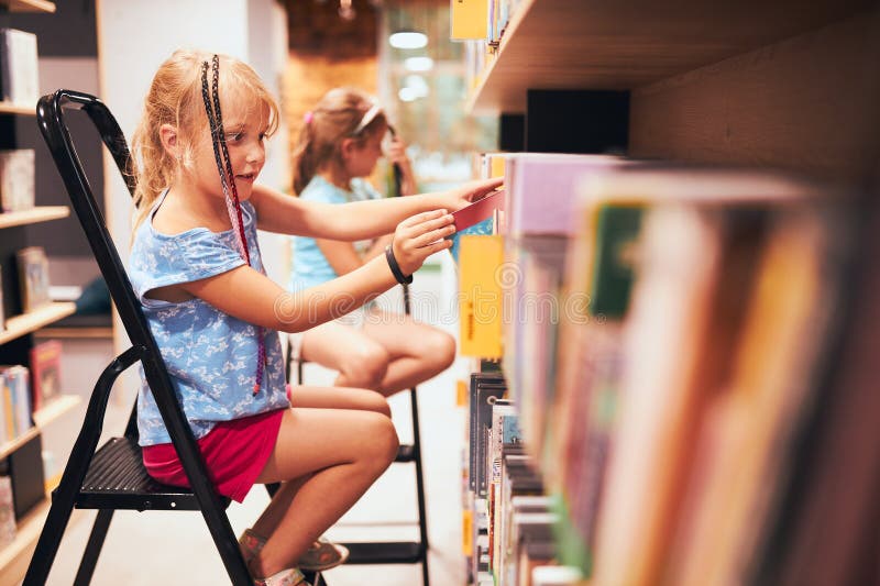 Schoolgirls Looking for Books in School Library. Students Choosing ...