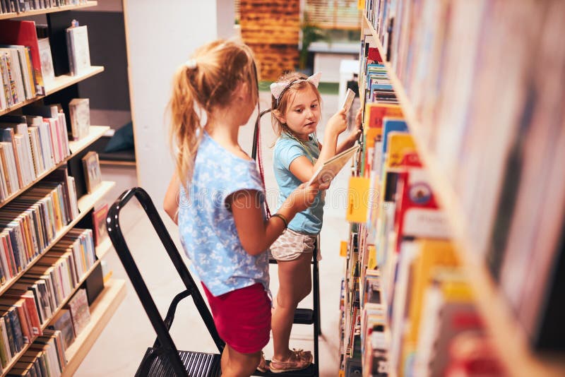 Schoolgirls Looking for Books in School Library. Students Choosing Set ...