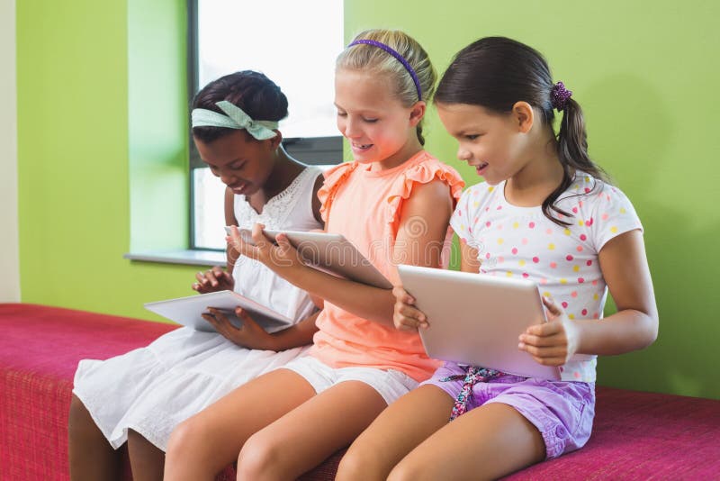 School Kids Sitting on Floor Using Digital Tablet in Library Stock ...