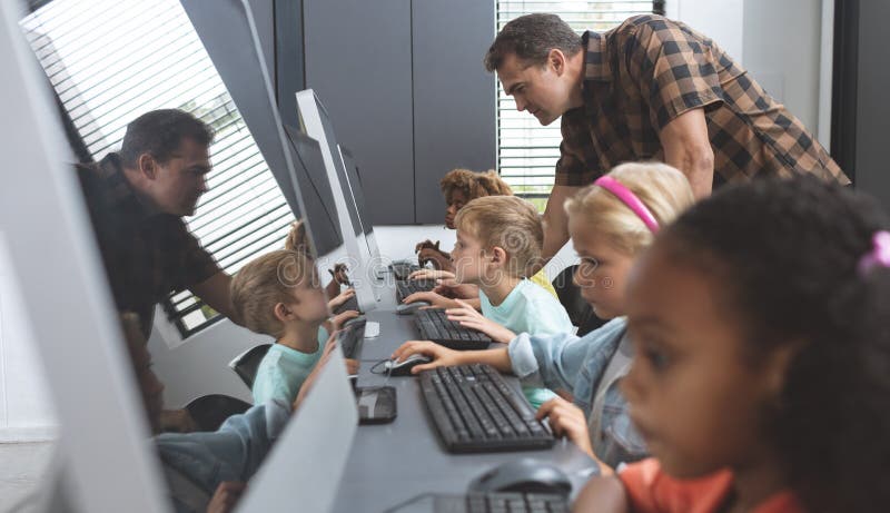 Schoolteacher Teaching To School Kids How To Use Computer Stock Photo ...