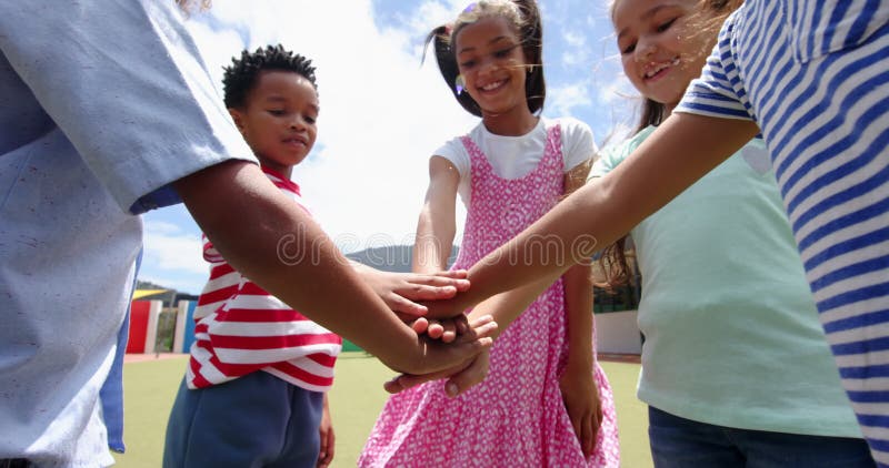In Schoolyard, Children Stacking Hands, Showing Teamwork and Unity ...