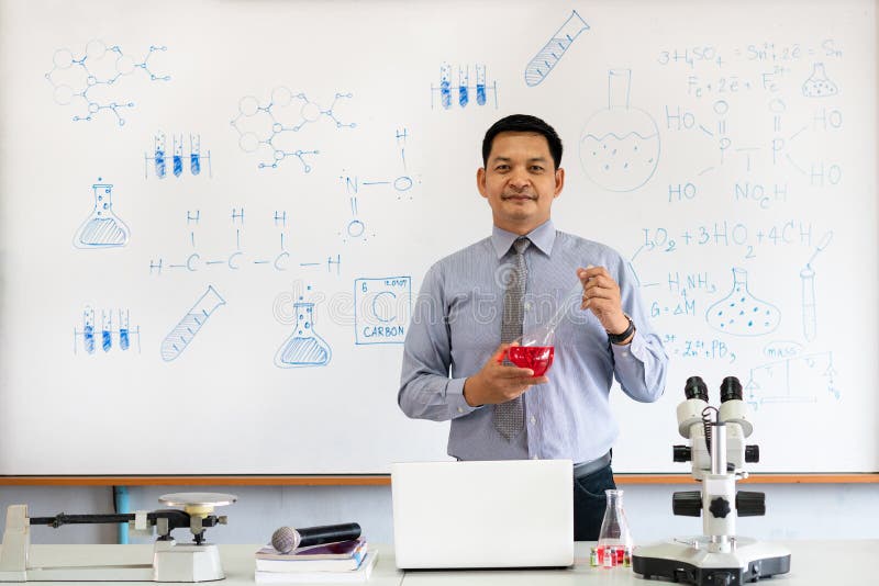 Science Chemistry Teacher Teaching with Microscope and Laptop in the ...