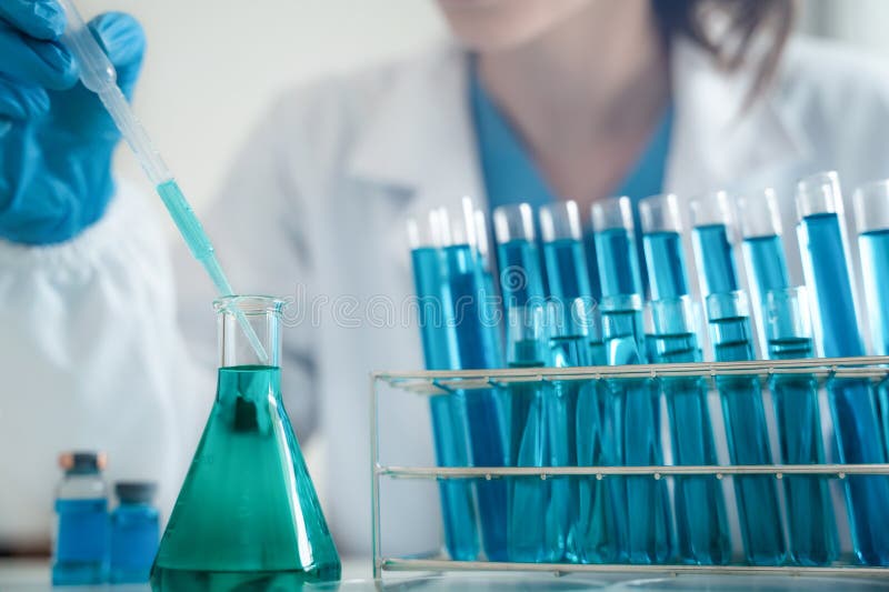 Science and Medicine, Scientist Analyzing and Dropping a Sample into a ...