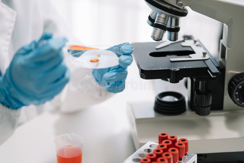 Science and Medicine, Scientist Analyzing and Dropping a Sample into a ...