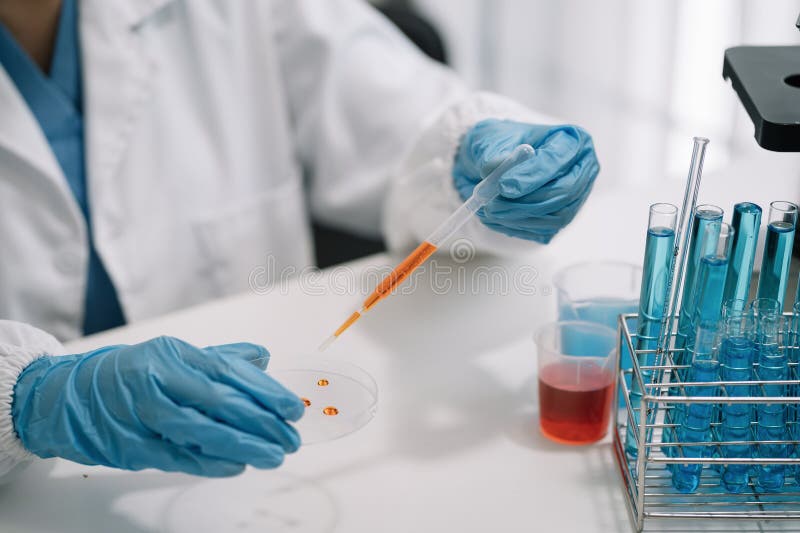 Science and Medicine, Scientist Analyzing and Dropping a Sample into a ...