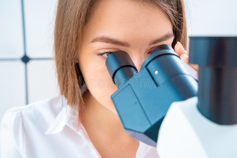 Young Woman Technician is Examining a Histological Sample, a Biopsy in ...