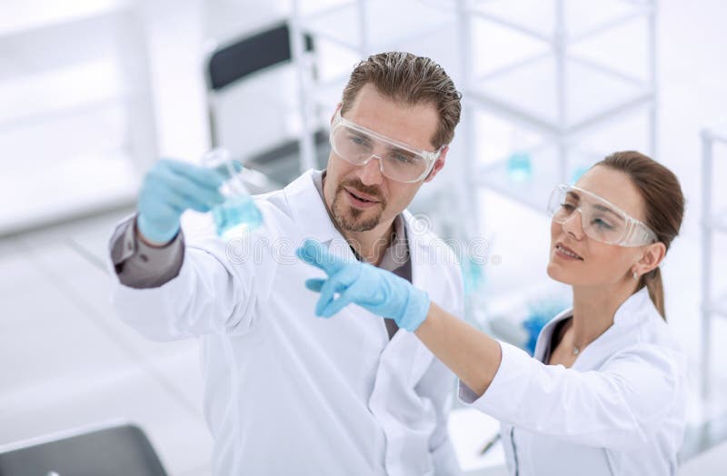 Scientist and Assistant Look at the Liquid in the Flask Stock Image ...