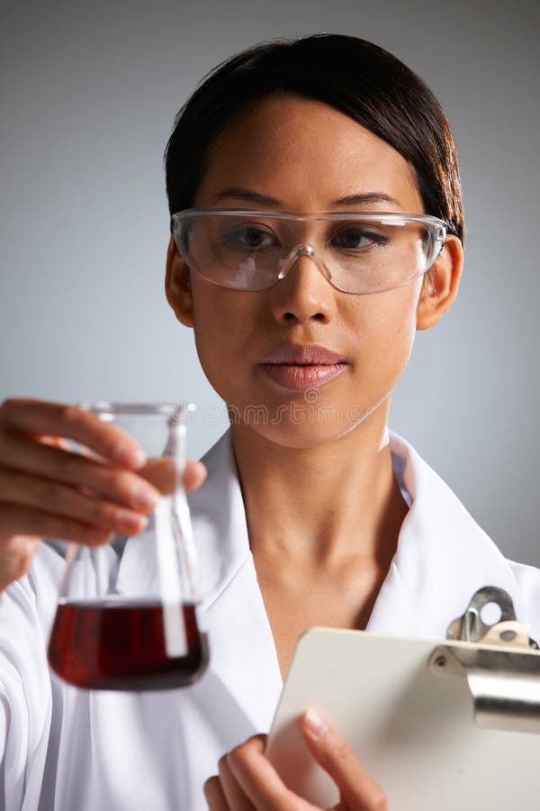 Scientist with Clipboard Examining Beaker Stock Image - Image of beaker ... Scientist with Clipboard Examining Beaker Stock Image - Image of beaker ...