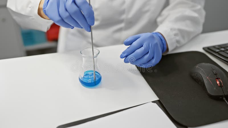 A Scientist Conducts an Experiment with a Blue Liquid in a Laboratory ...
