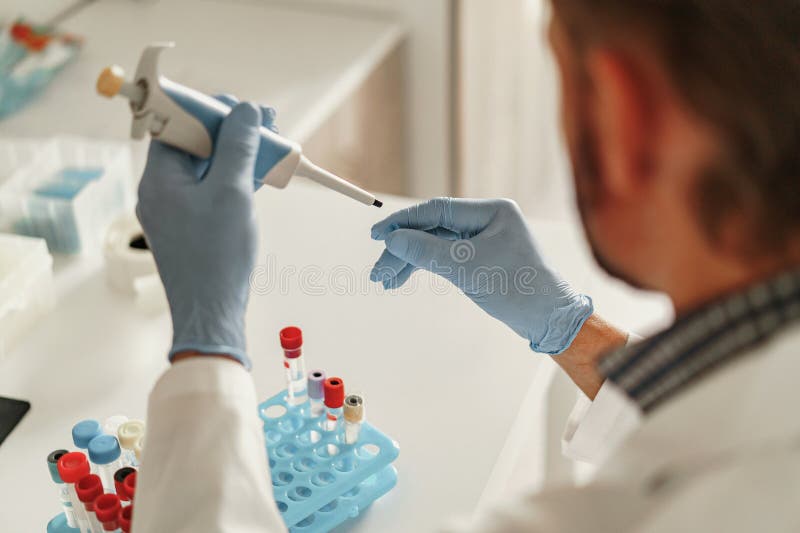 Back View of Scientist is Using Micropipette for Biochemical Test ...