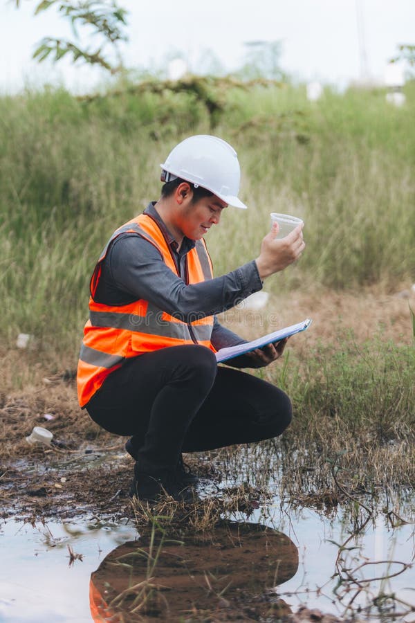 Scientist Ecologist Taking a Water Sample and Reading Ph Value at River ...