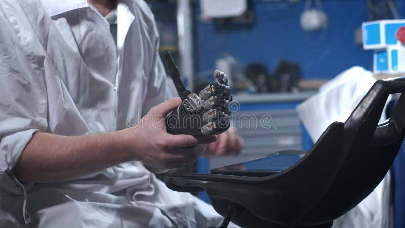 Engineer with Prosthetic Hands Works at a Factory, Drilling a Wooden ...