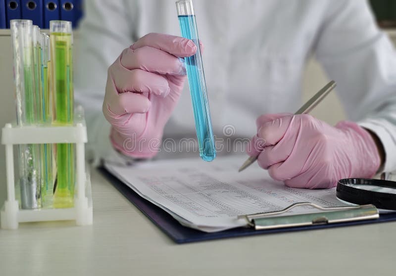 A Scientist Examines a Blue Liquid in a Test Tube in a Lab. Lab ...