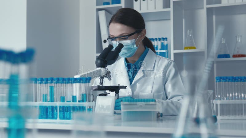 A Scientist Examines Viruses and Bacteria Under a Microscope. a ...