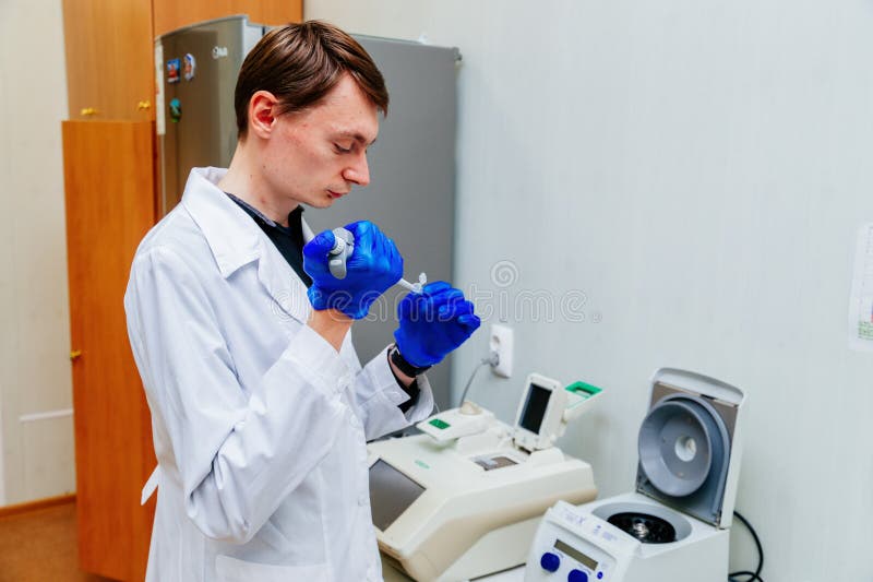 Scientist with Gloved Hand Putting DNA Sample into Real-time PCR-cycler ...