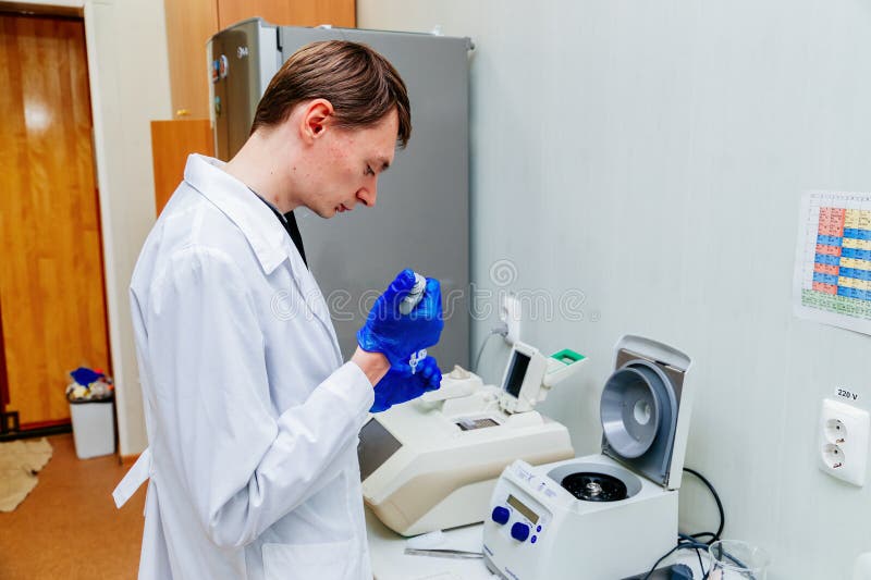 Scientist with Gloved Hand Putting DNA Sample into Real-time PCR-cycler ...