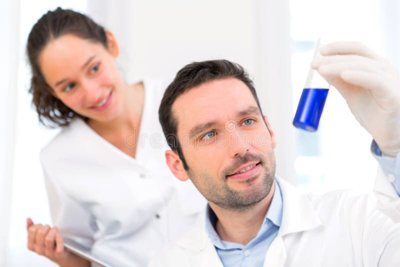 Scientist and His Assistant Working in a Lab Stock Image - Image of ...
