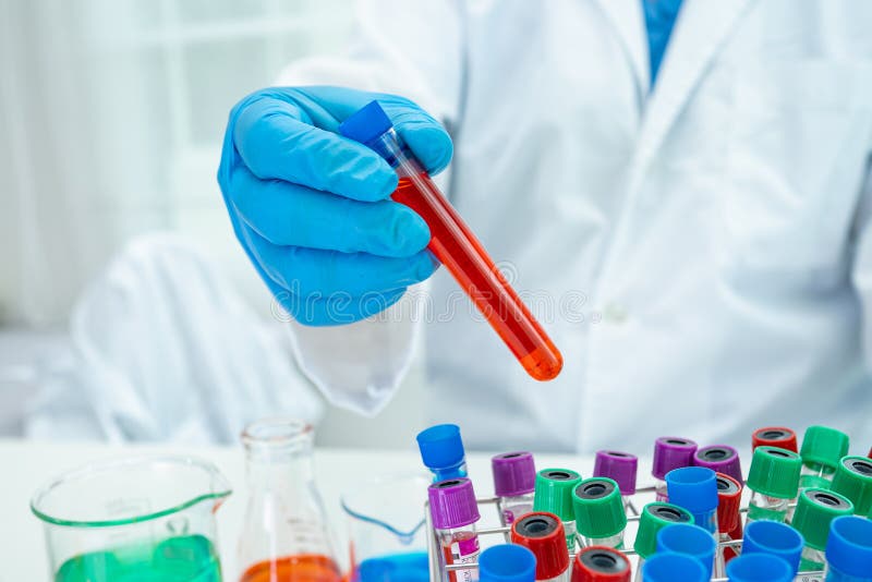 Scientist Holding and Analysis Tube of Micro Biological Sample with a ...