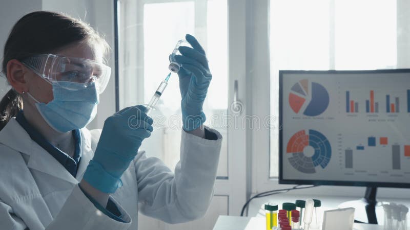A Scientist in a Lab Conducts Experiments with a Syringe, Focusing on ...