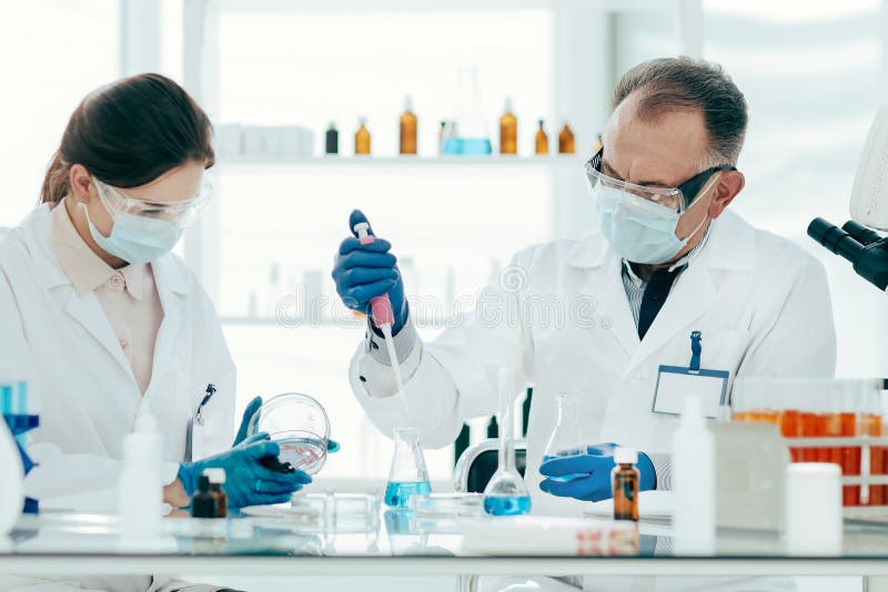 Scientist and Laboratory Assistant Conduct Research in the Laboratory ...