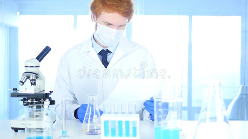Scientist in Laboratory Reading Documents, Paperwork of Result of ...