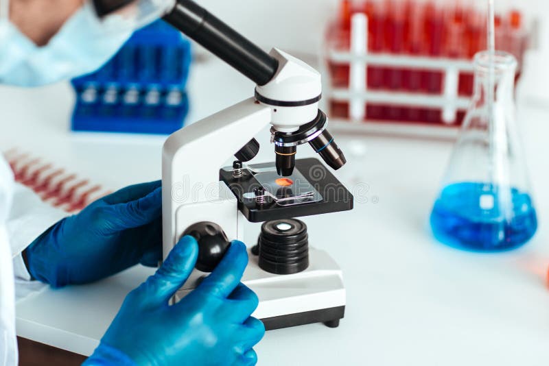 Scientist Looking at a Drop of Blood through a Microscope. Stock Image ...