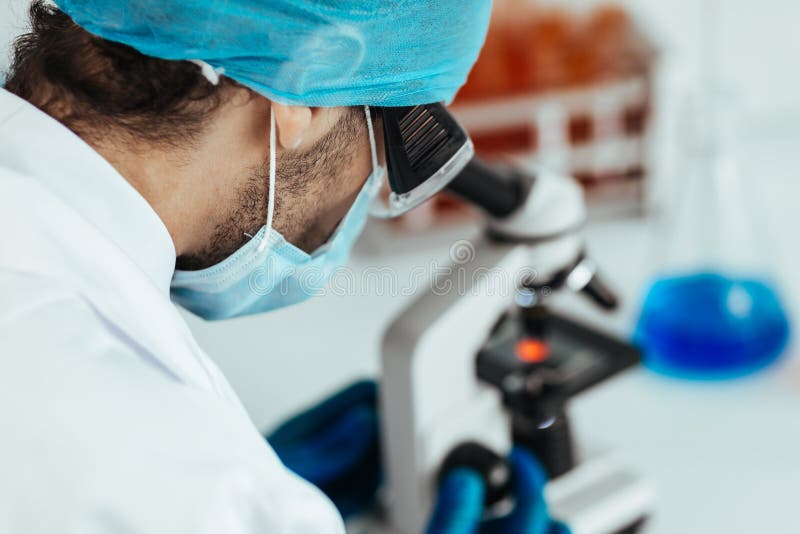 Scientist Looking at a Drop of Blood through a Microscope. Stock Image ...