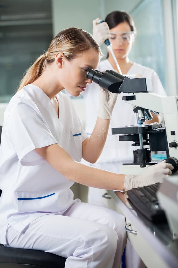 Scientist Looking into Microscope in Lab Stock Photo - Image of girl ...