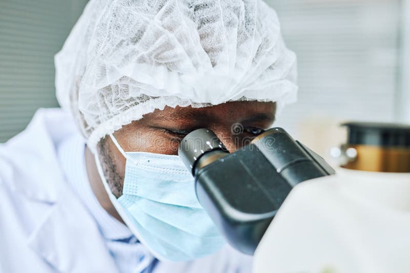 Scientist Looking in Microscope Working in Laboratory and Doing Tests ...