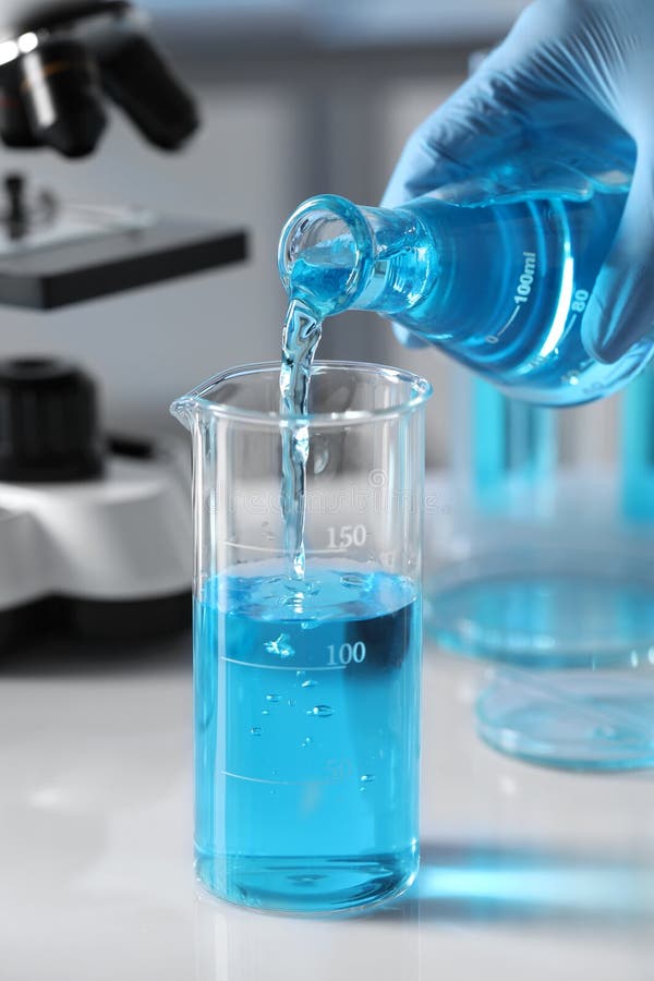 Scientist Pouring Light Blue Liquid from Flask into Beaker in ...