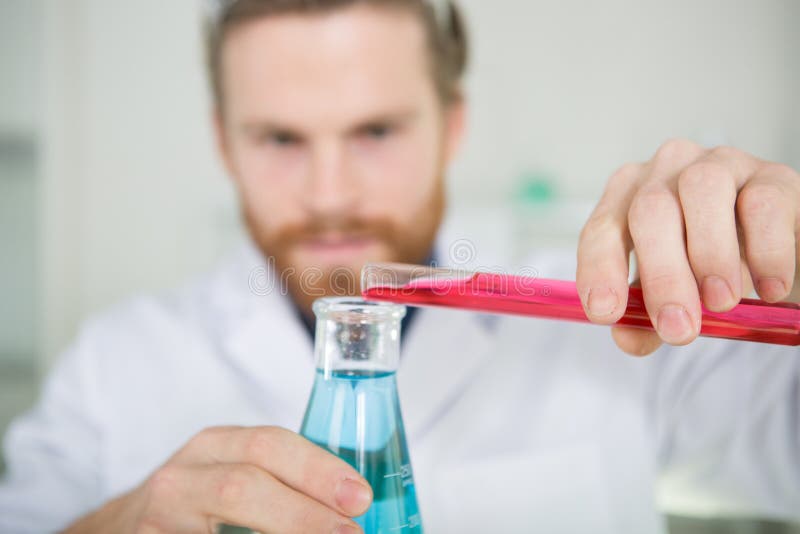 Scientist Pouring Liquid from Test Tube into Erlenmeyer Flask Stock ... Scientist Pouring Liquid from Test Tube into Erlenmeyer Flask Stock ...