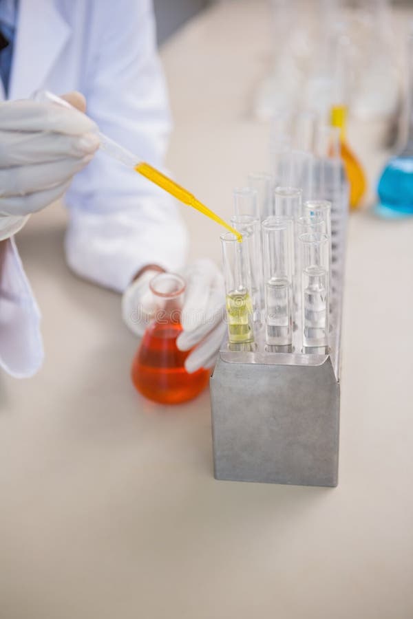 Scientist Pouring Orange Fluid in Test Tube Stock Image - Image of ...