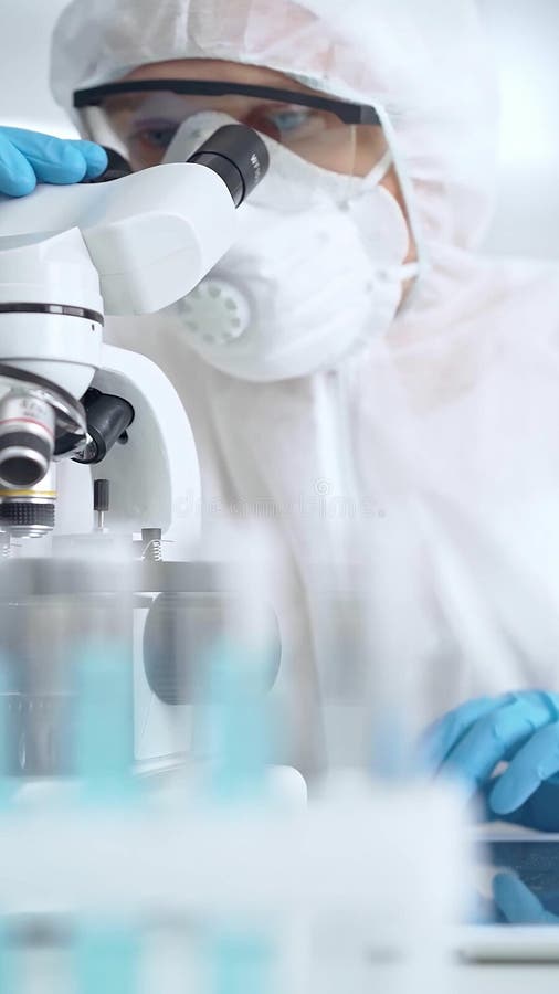 Scientist in Ppe Analyzing Samples with Microscope. Close-up of a ...