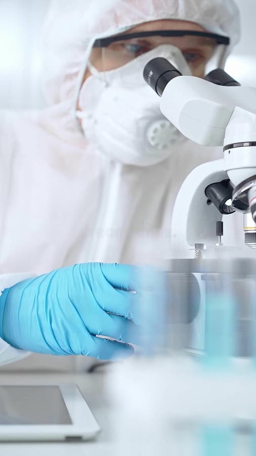 Scientist in Ppe Analyzing Samples Using a Microscope in a Laboratory ...